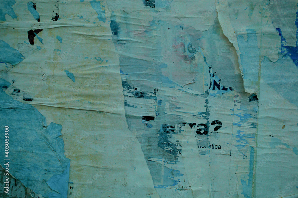 Background texture of remainder of old posters and notices on a wall ...