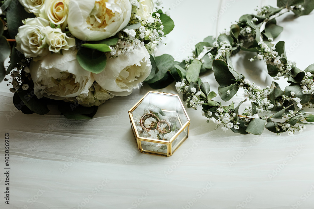 Wedding details. two classic gold wedding rings in a glass box and a ...