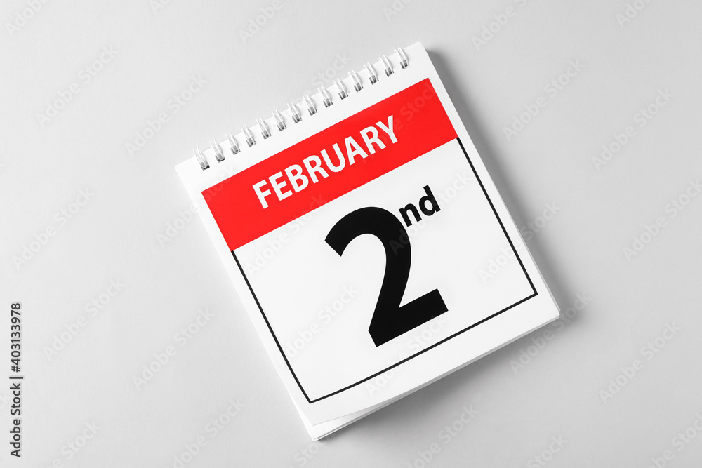 Top view of calendar with date February 2nd on light background ...