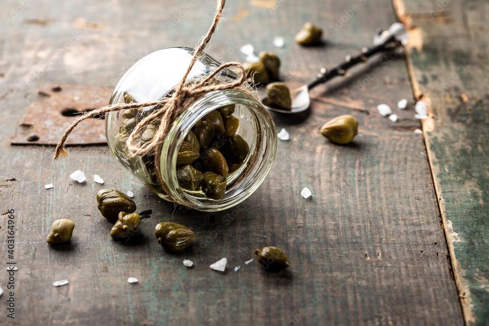 pickled capers on a dark wooden background. Edible flower buds of ...
