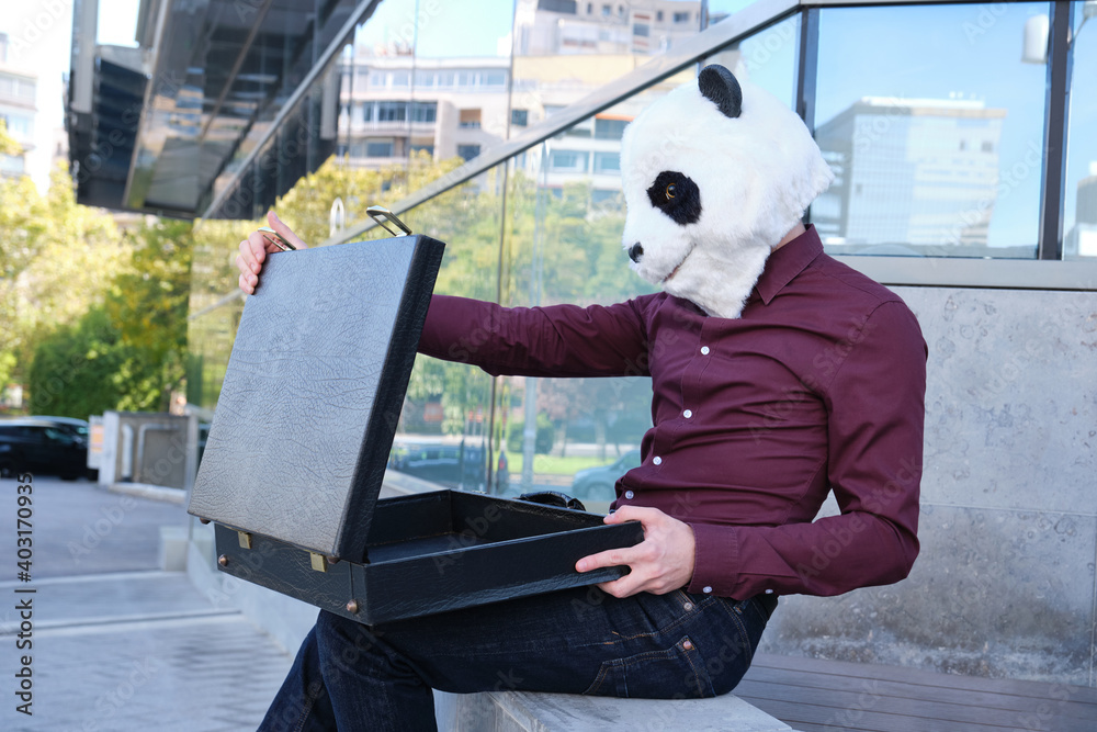 Male robber wearing a panda head mask have stolen a briefcase and is ...