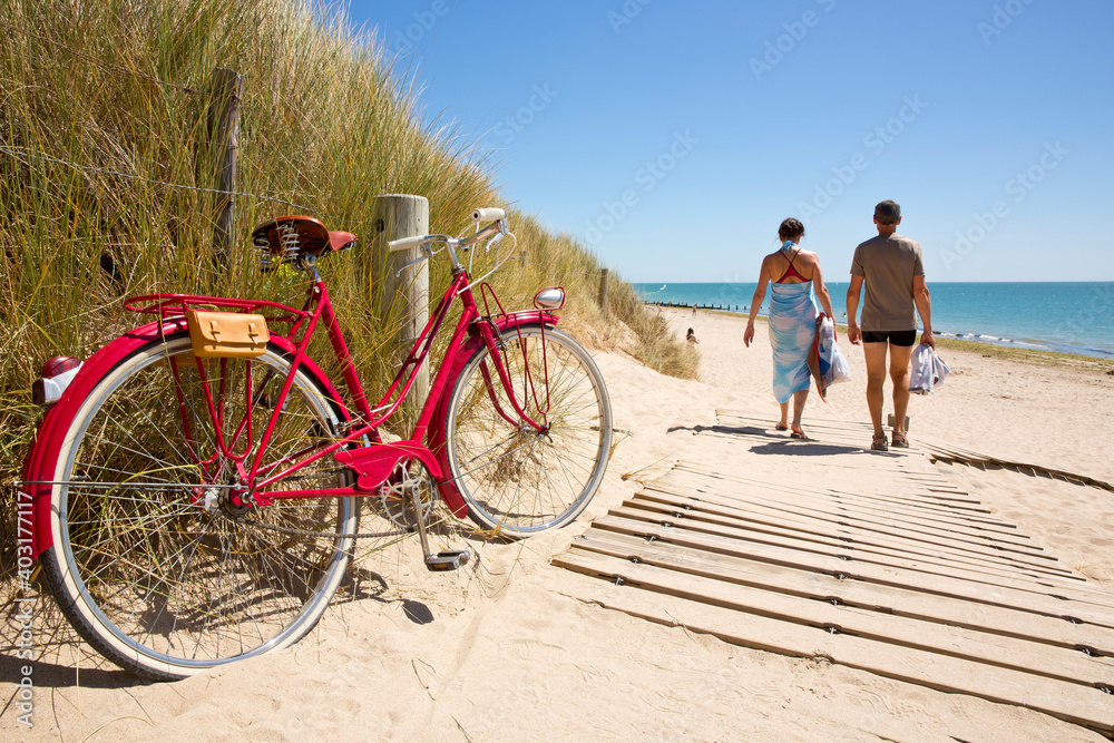 Balade en bord de mer, deux touristes dans les dune, un vieux vélo ...
