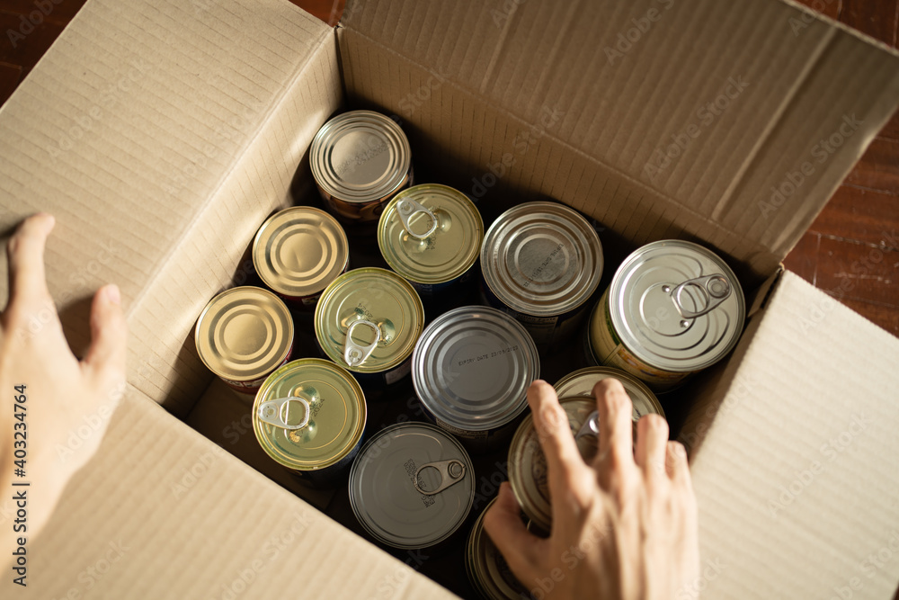 Storing canned foods in a cardboard box Stock-Foto | Adobe Stock