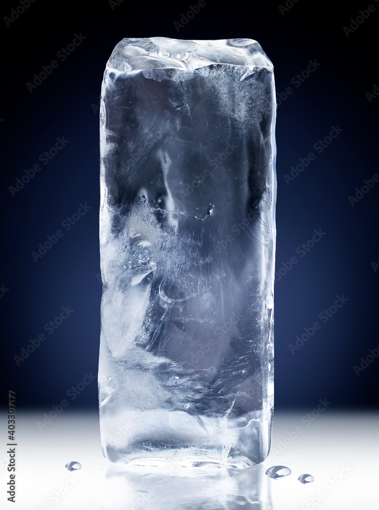 Vertical rectangular block of ice isolated on dark blue background with ...