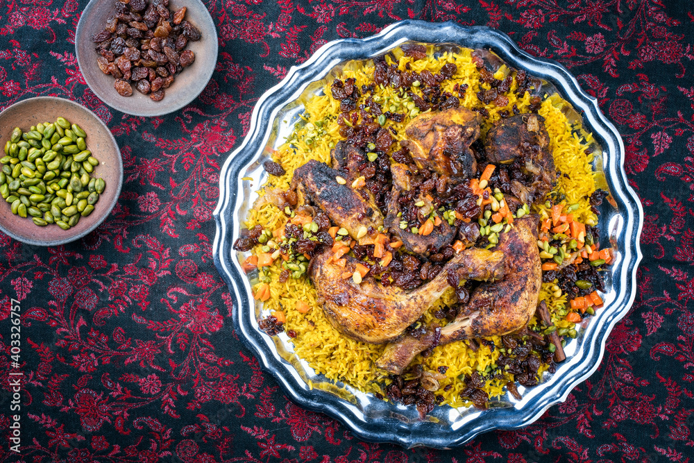 Traditional fried Arabic chicken majboos with chicken leg and jeweled ...
