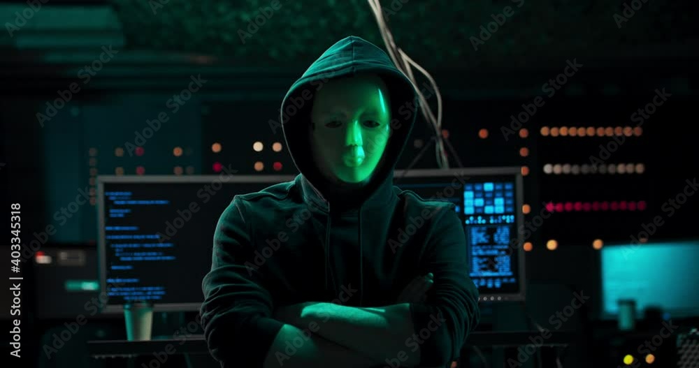 Close-up Shot of a Masked Hacker in a Hoodie Sitting in the Middle of ...