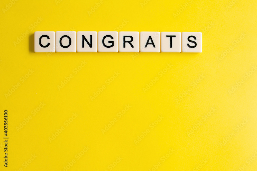 the words congrats written as a flat lay in wood scrabble tiles on a ...