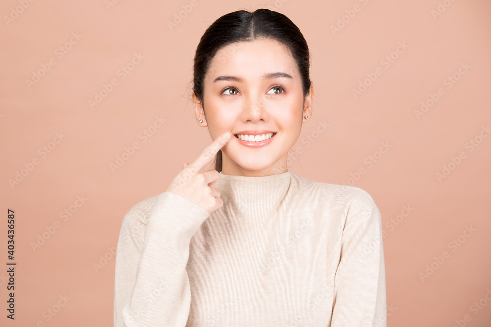Portrait of smiling woman pointing at her nice teeth and mouth isolated ...