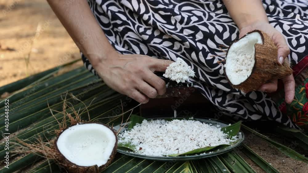 Vidéo Stock Woman hand grating fresh raw coconut cut open in half 4K ...