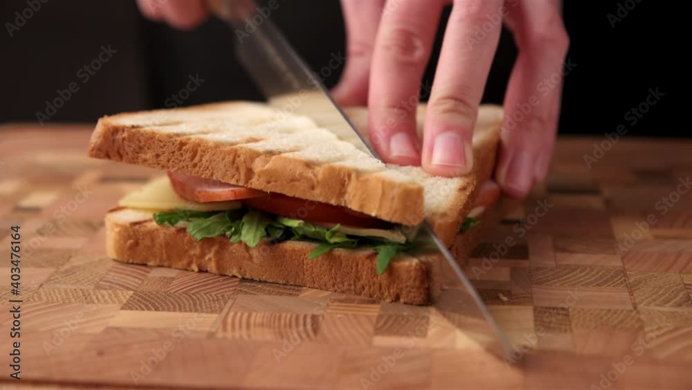 Woman cuts a sandwich with knife Stock Video | Adobe Stock
