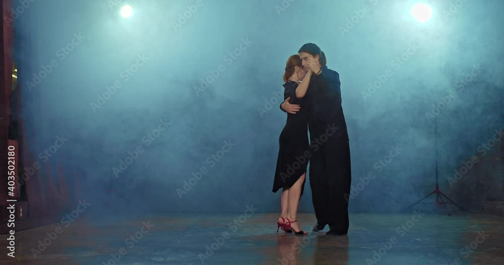 Beautiful woman dancing romantic tango with elegant man in black suit ...