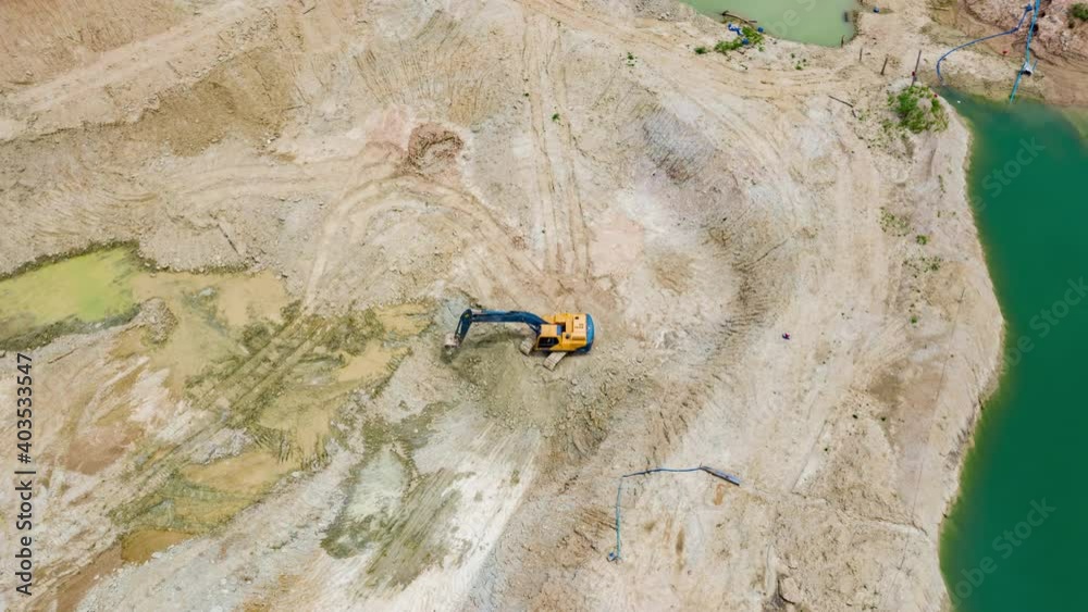 Aerial view, orange excavator with truck working in quarries site ...