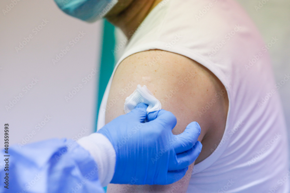 Details with a man getting an intramuscular injection with the Sars-Cov ...