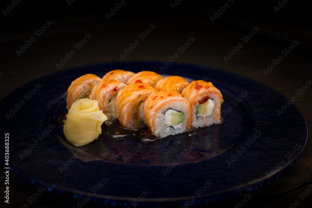 Side view of Japanese sushi roll with salmon tataki on top served with ...