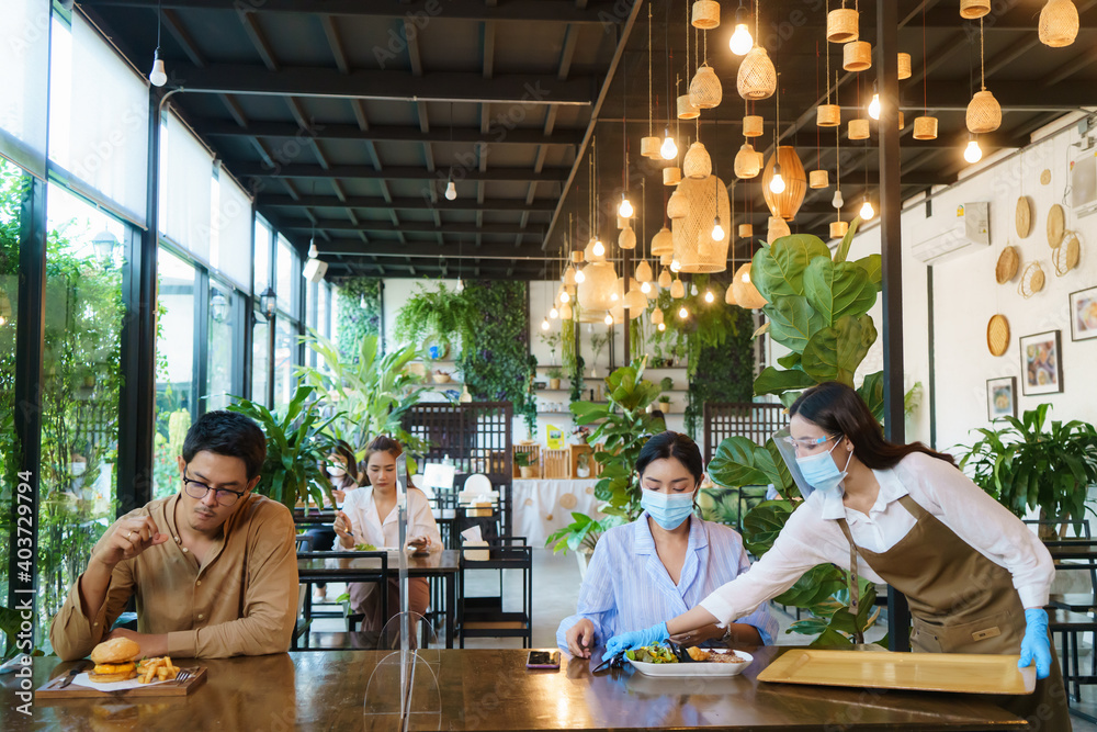 Asian woman waering mask and asian people eating food alone at table ...