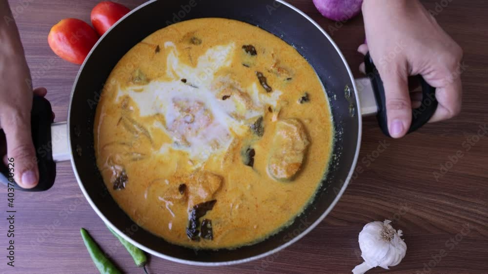 Woman cooking Kerala fish curry with coconut milk , cooking spicy Goan ...