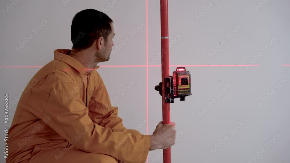 Professional worker using laser level in construction at construction ...
