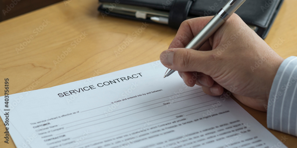 Hand of a men holding a pen writing a service contract form. contract ...