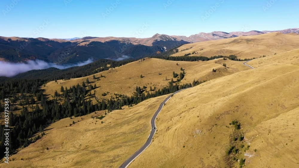 Aerial view of car driving down country road through rural rolling ...