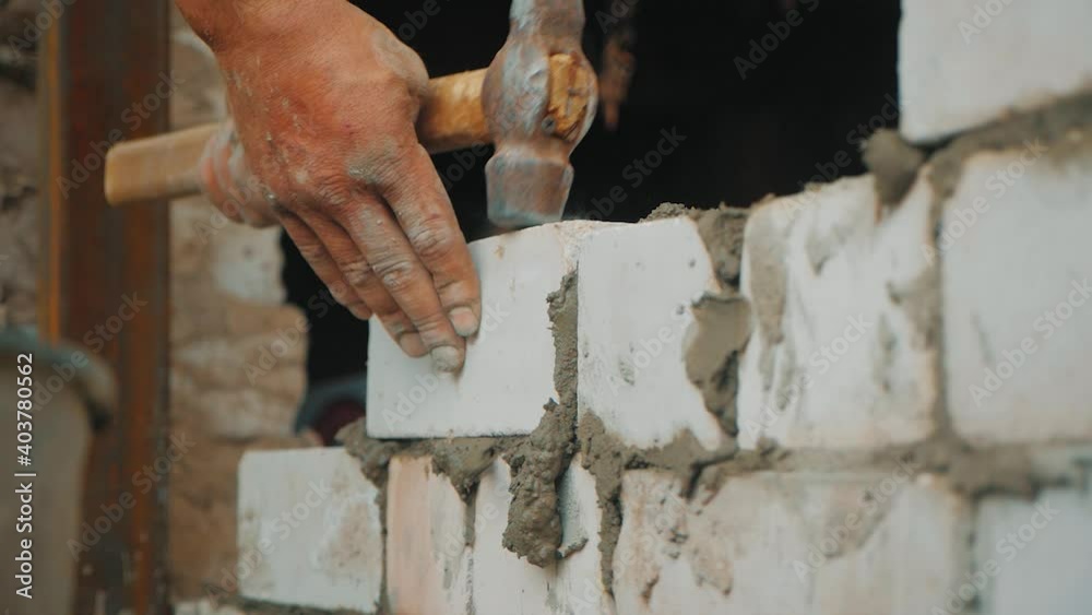 Construction worker or mason laying bricks and creating walls ...