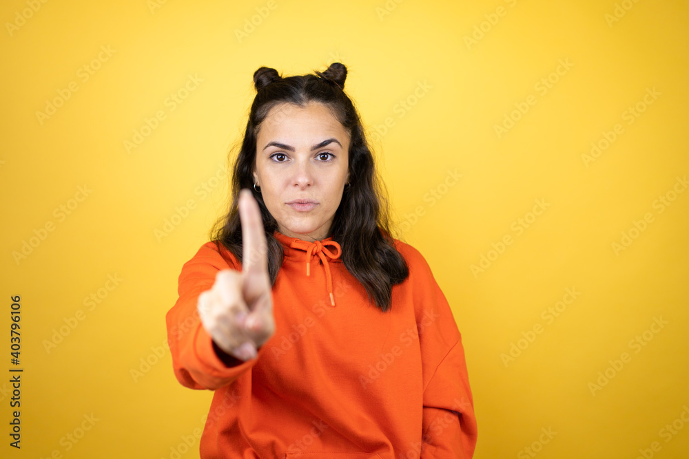Young beautiful woman wearing sweatshirt over isolated yellow ...