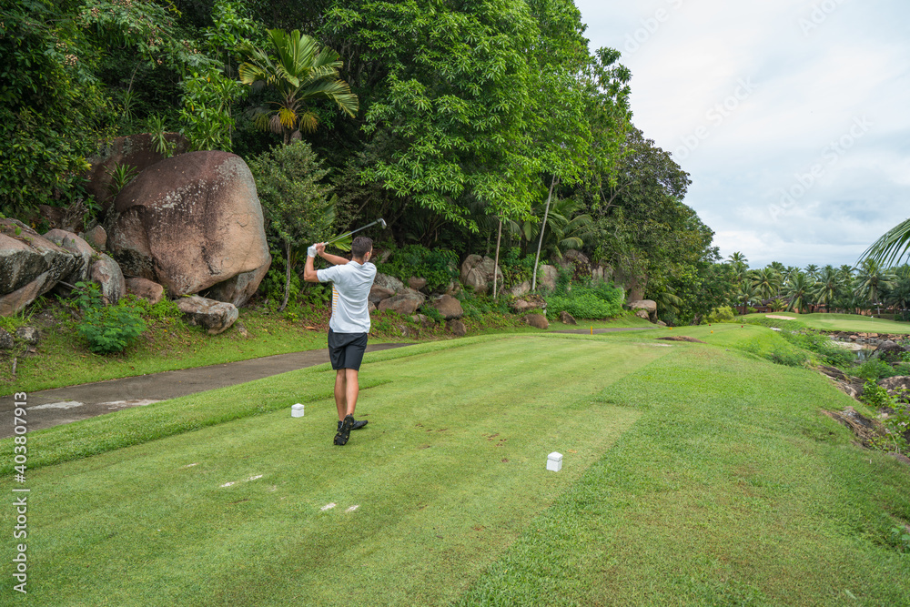 Golfer tee shot on Lemuria Golf course hole nr. 2 Resort Praslin ...