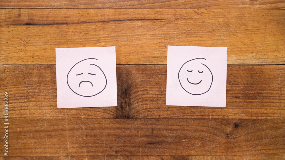 Sticky note happy and sad face emotions on wooden wall background ...