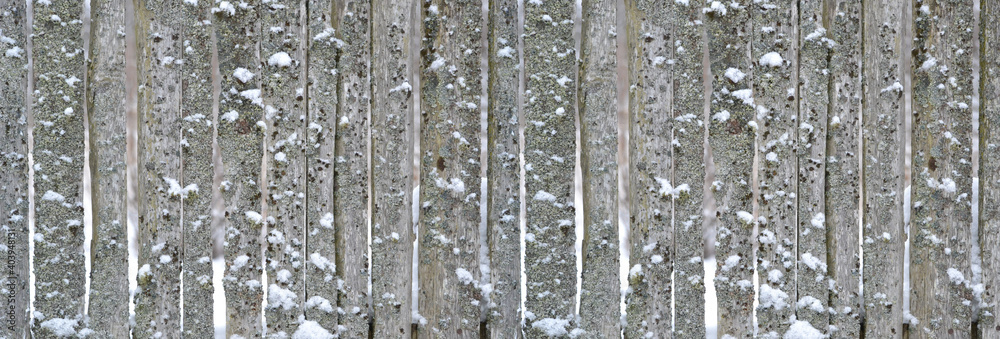 Vintage rustic wooden fence covered with snow flakes. Winter panoramic ...
