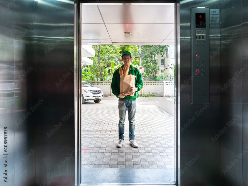 Asian delivery man standing and holding bread breakfast or grocery food ...