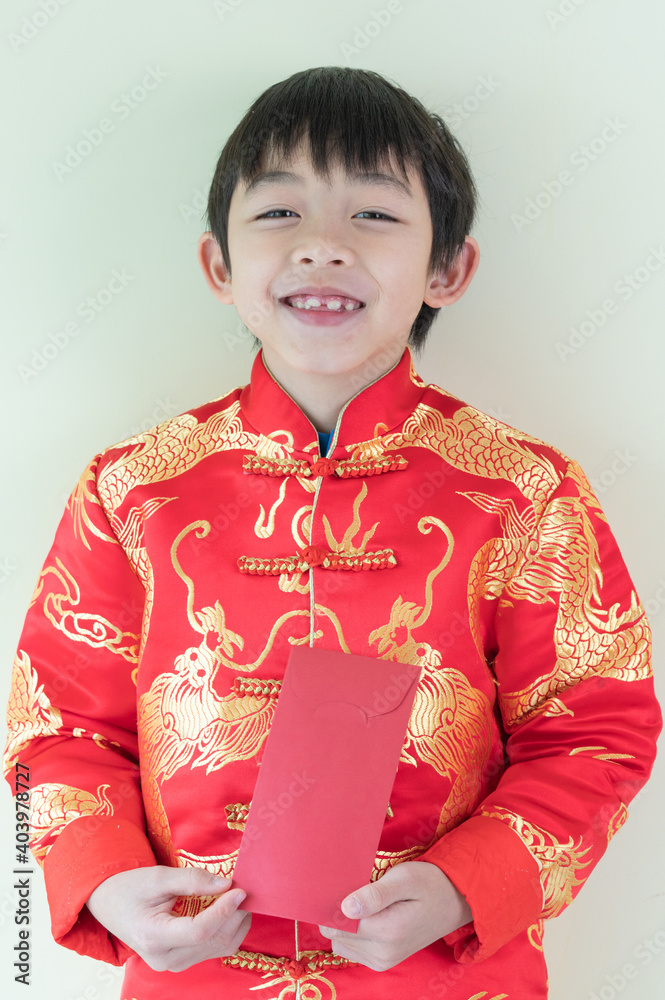 One smiling Asian boy is holding the red packet in his hand. A happy ...