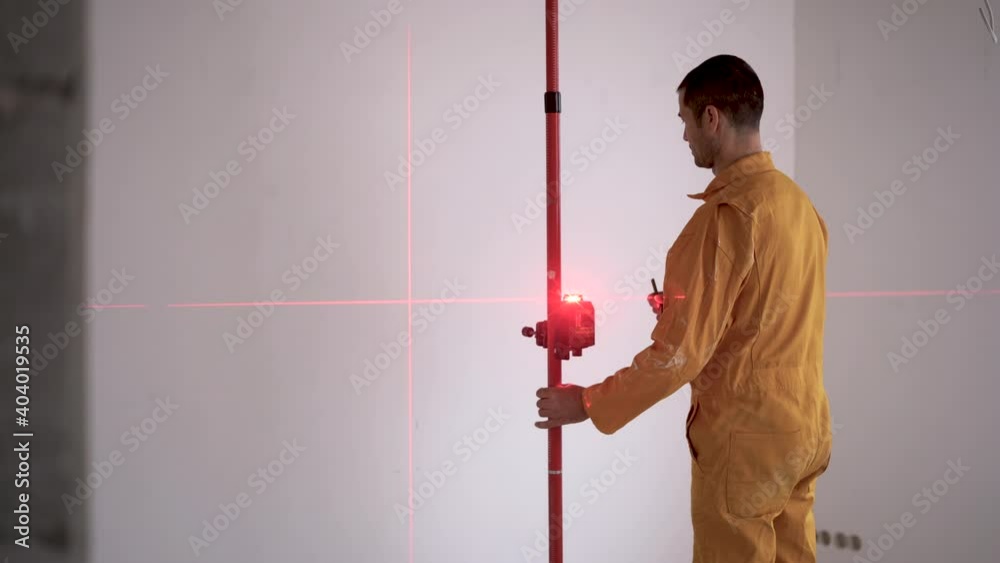 Professional worker using laser level in construction at construction ...