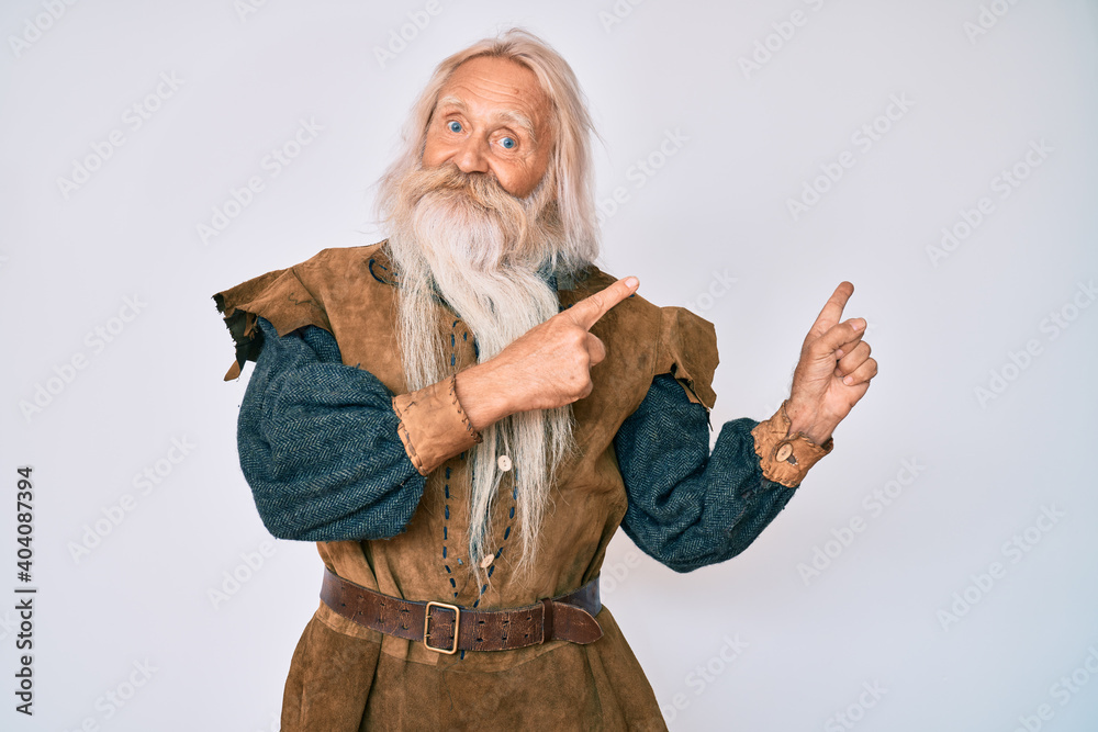 Old senior man with grey hair and long beard wearing viking traditional ...