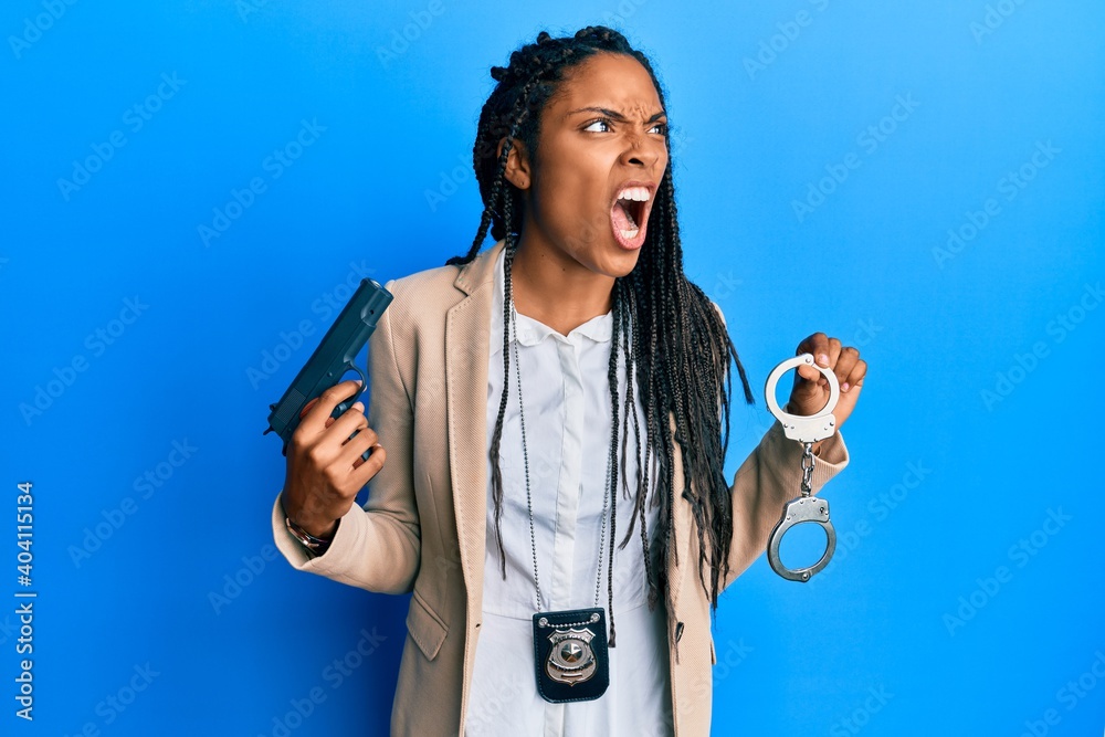 African American Police Woman Holding Gun And Handcuffs Angry And Mad