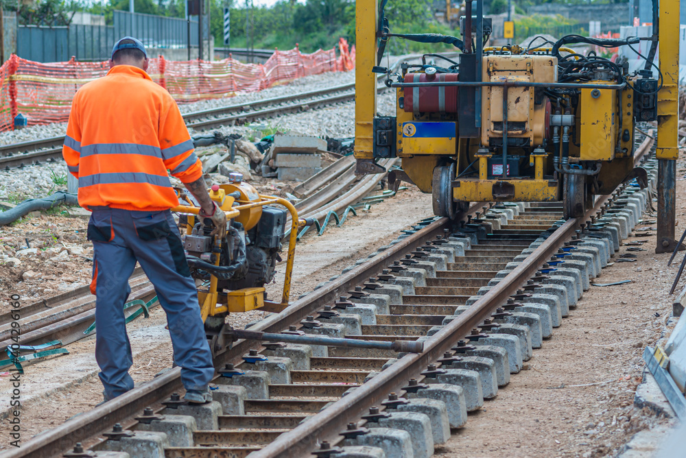 Railway workers bolting track rail. Detail worker with mechanical ...