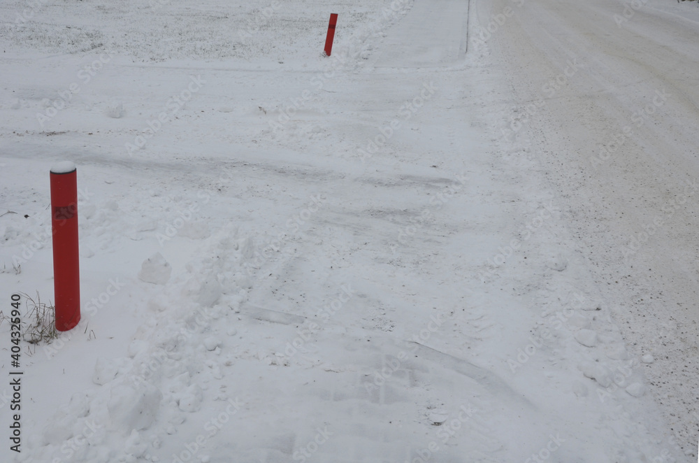 connection of a side dirt road to an asphalt road. the turn is ...