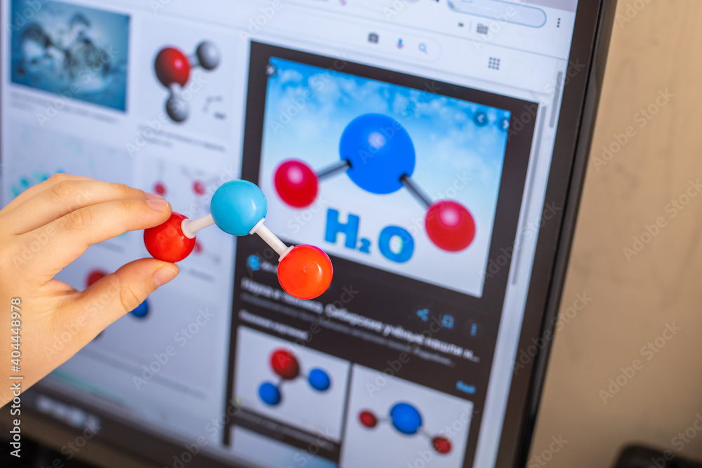 The boy collects a water molecule model from the constructor using the ...