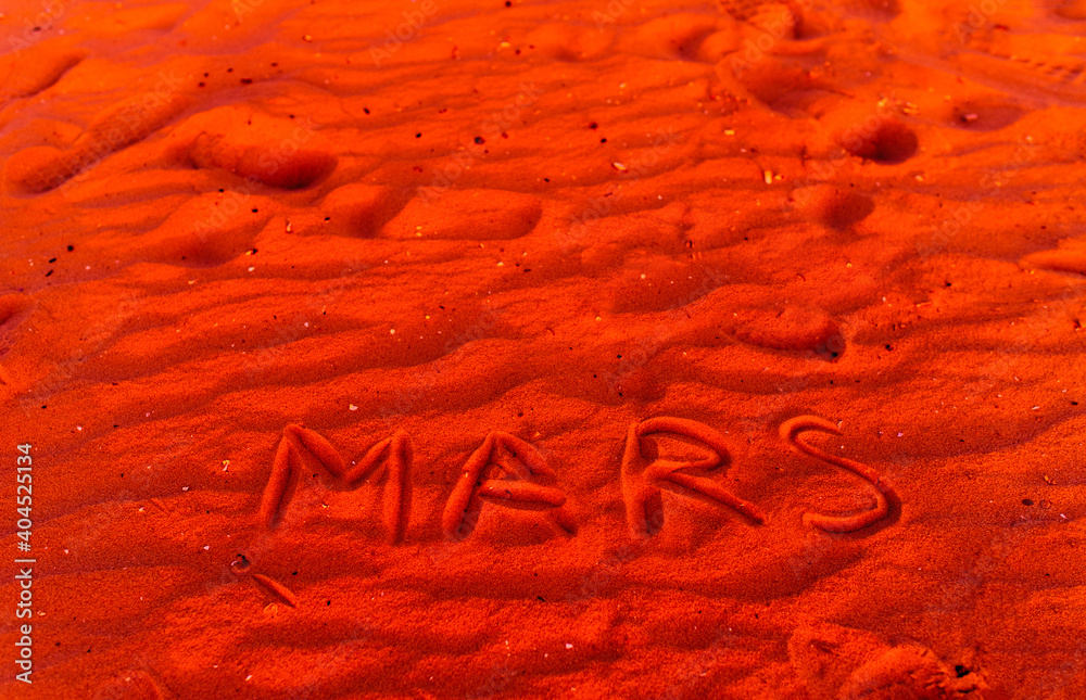 The handwritten lettering MARS is written in red sand. The concept of ...