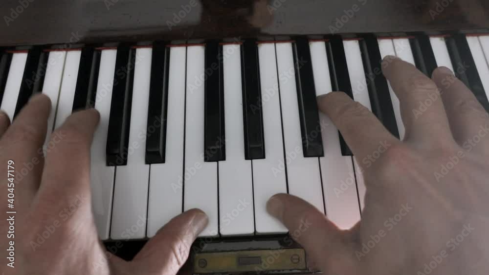 Piano being played by two hands. Close up shot of fingers playing the ...