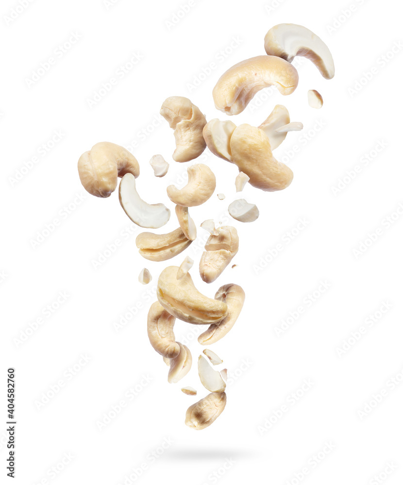 Crushed cashew nuts into many pieces in the air isolated on white ...