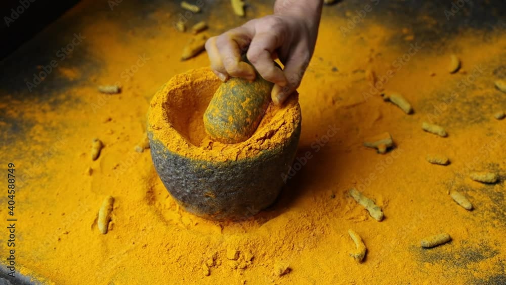 Stockvideo Woman hand powdering Indian spices turmeric powder stone ...