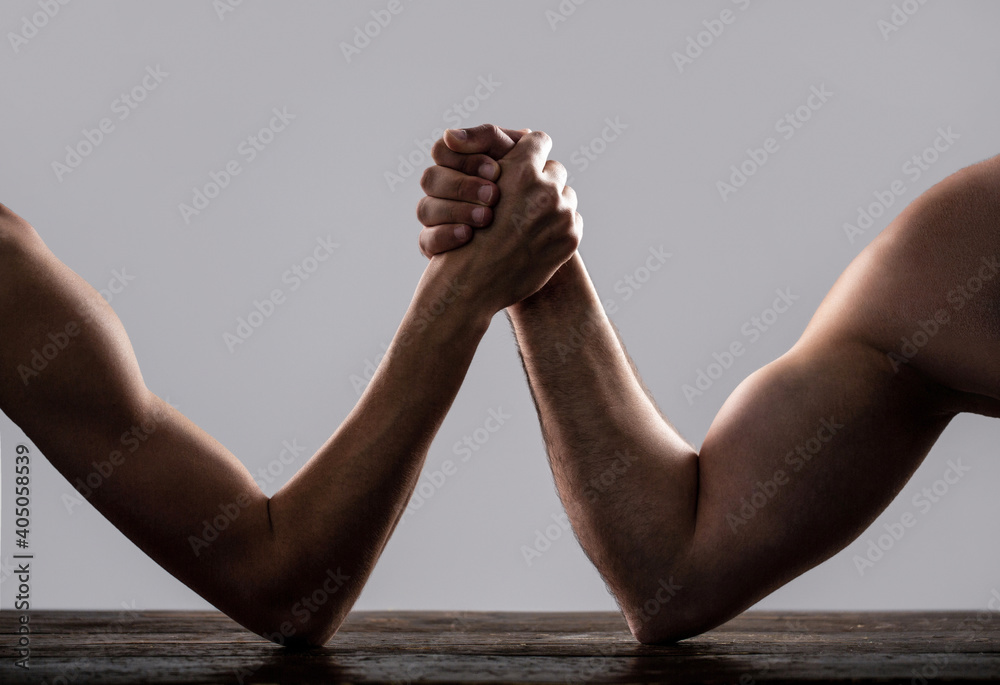 Arm wrestling. Heavily muscled man arm wrestling a puny weak man. Arms ...