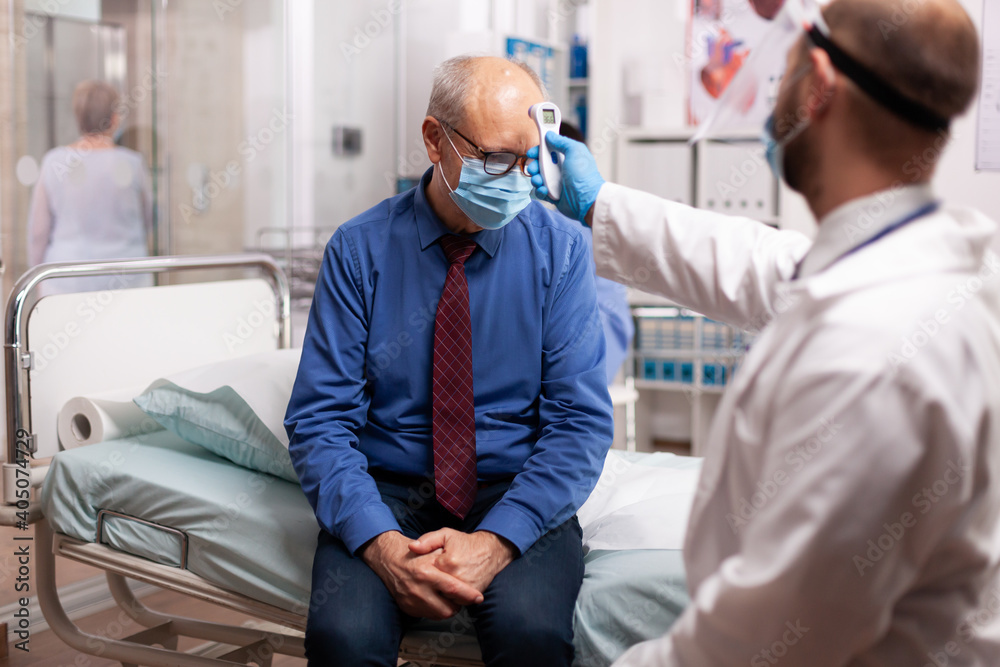 Senior patient in hospital getting body temperature check in hospital ...