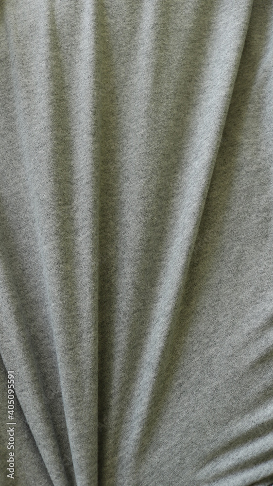 Stretched gray sports fabric with formed stripes of folds emanating ...