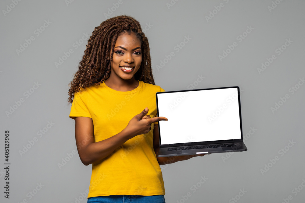 Young smiling african woman standing with laptop computer isolated on ...