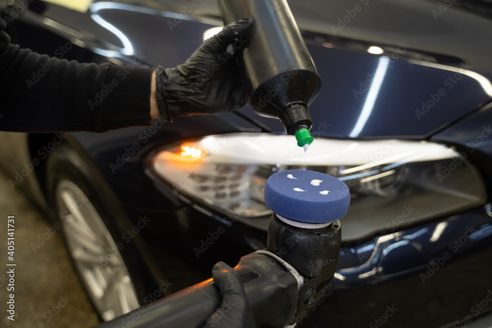 Detailing master applies car polish paste to the polisher. Vehicle ...