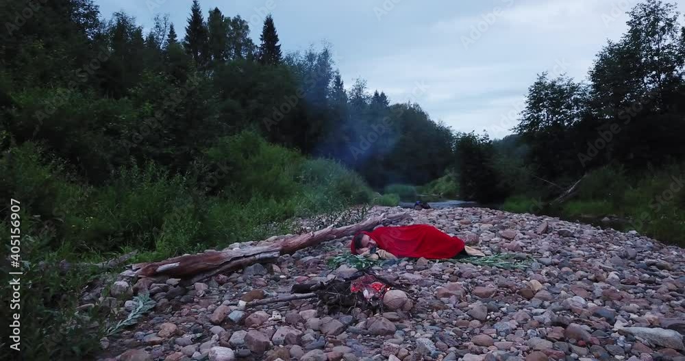 Vidéo Stock girl in a red cloak is sleeping by fire. The fire is ...