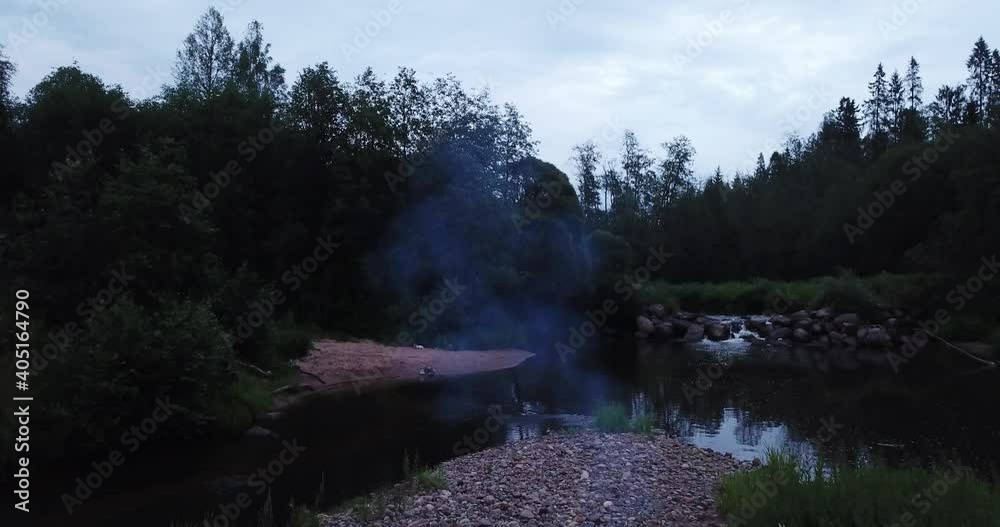 girl in a red cloak is sleeping by fire. The fire is burning, the smoke ...