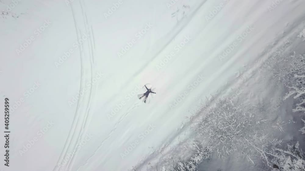 ANTENNA. A young girl lies on the snow and draws an angel. The camera ...