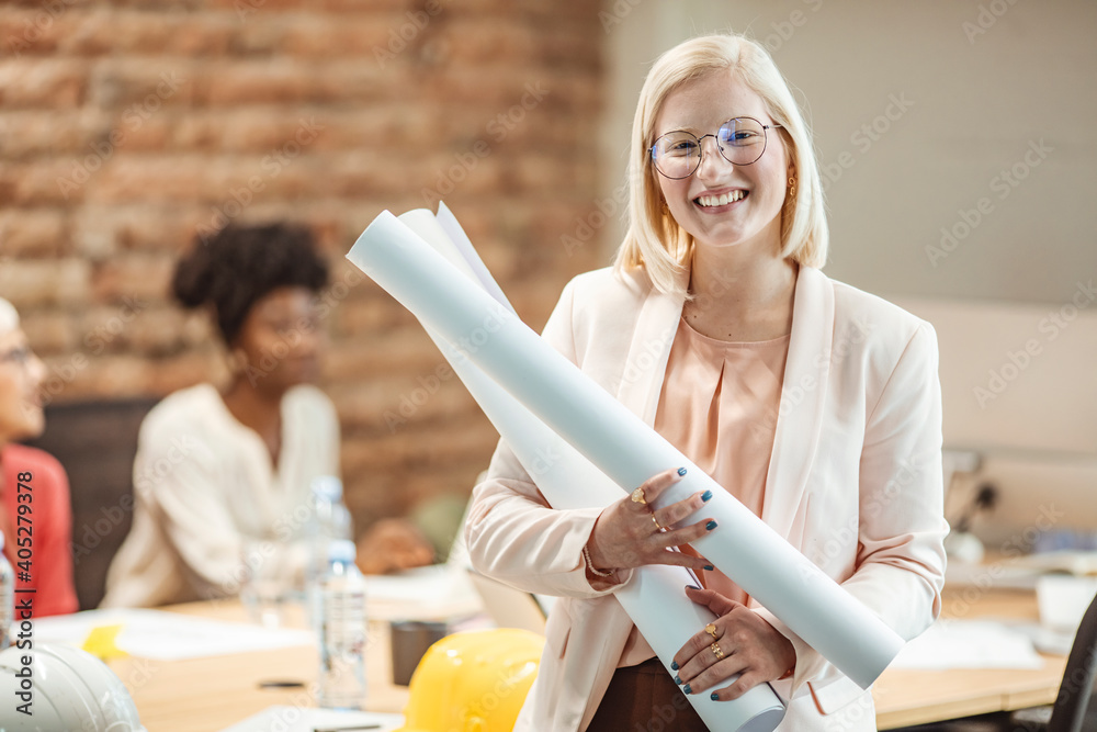 Young Woman Student architect holding blueprints. Smiling girl portrait ...
