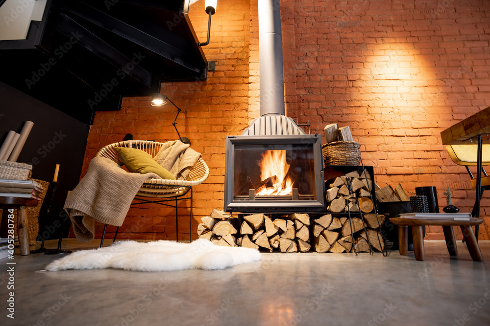 Cozy fireplace with firewood in the loft style home interior with brick ...